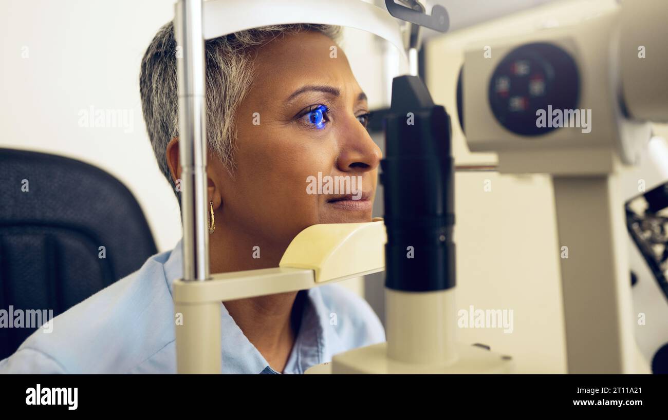 Eye test, machine and a woman for an optometry problem, scanning retina ...