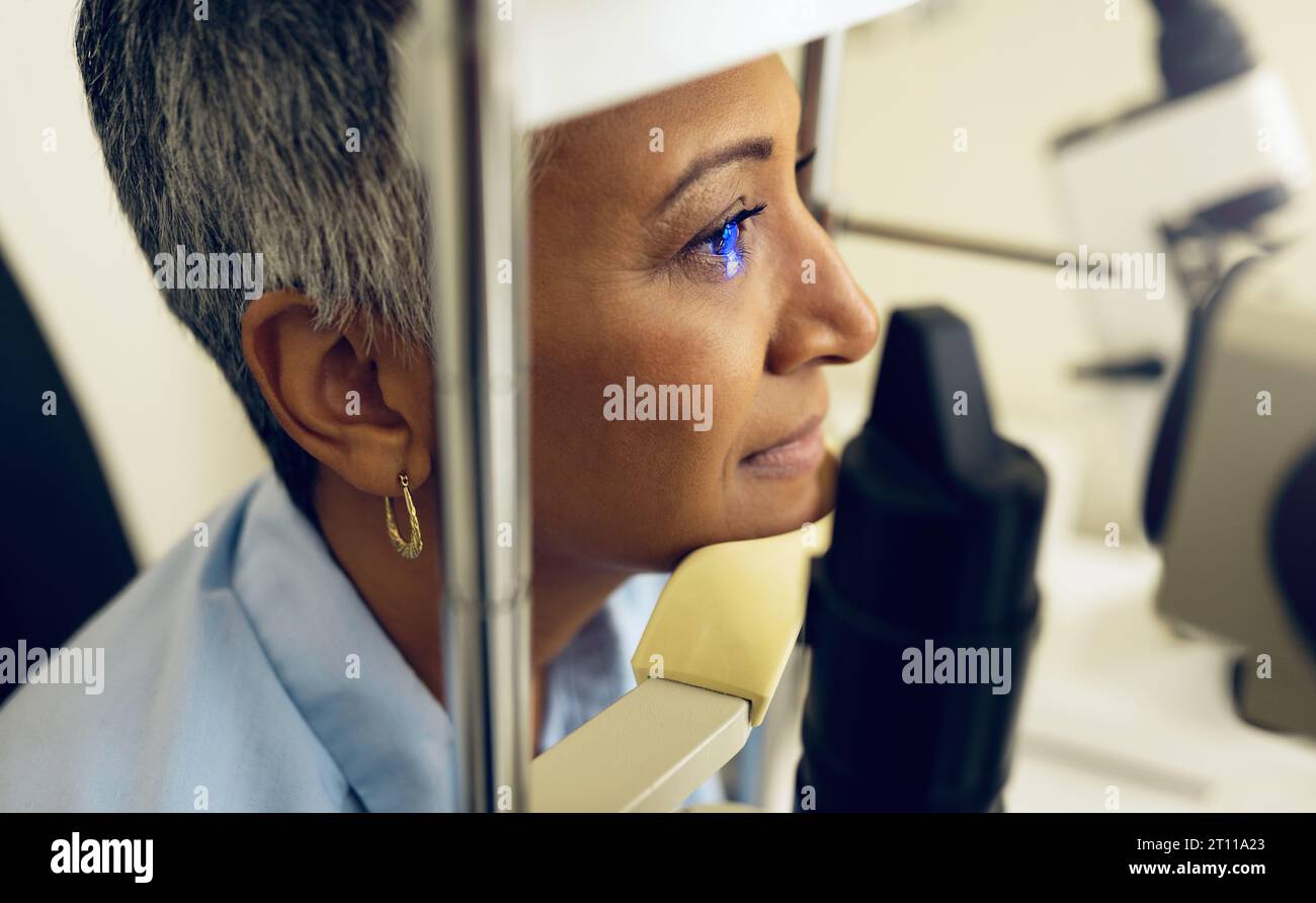 Eye test, machine and a woman for optometry help, scanning retina or ...