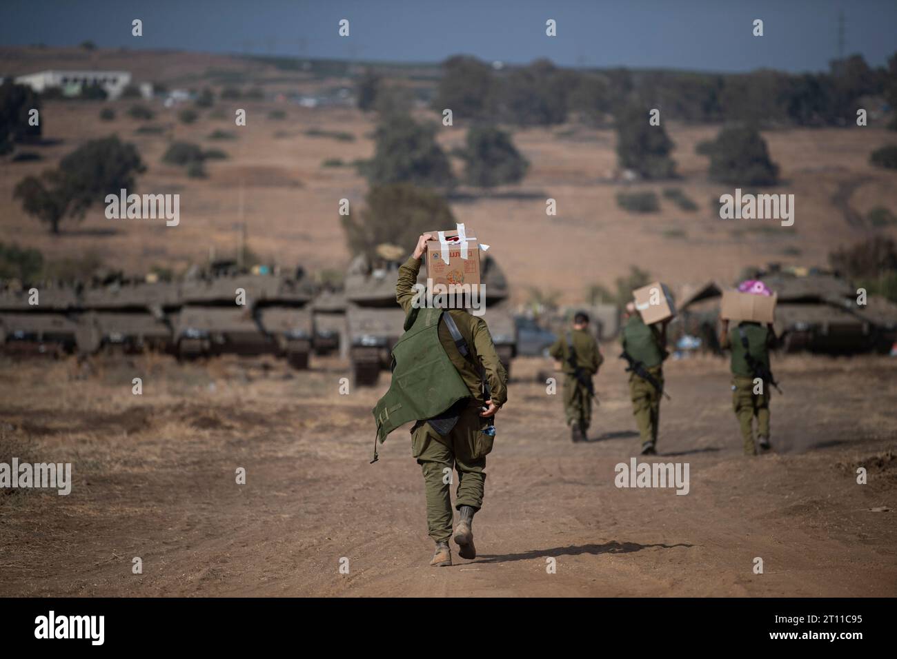 Israeli soldiers carry supplies near the border with Lebanon on Tuesday ...