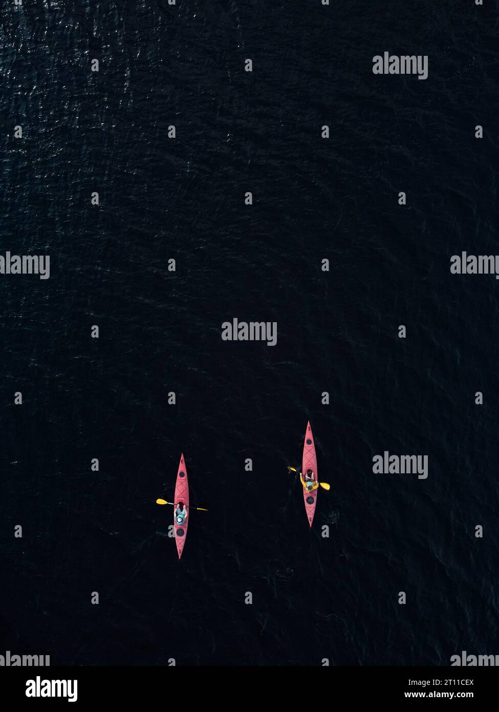aerial view of two red kayaks in dark blue lake water. Drone photo ...