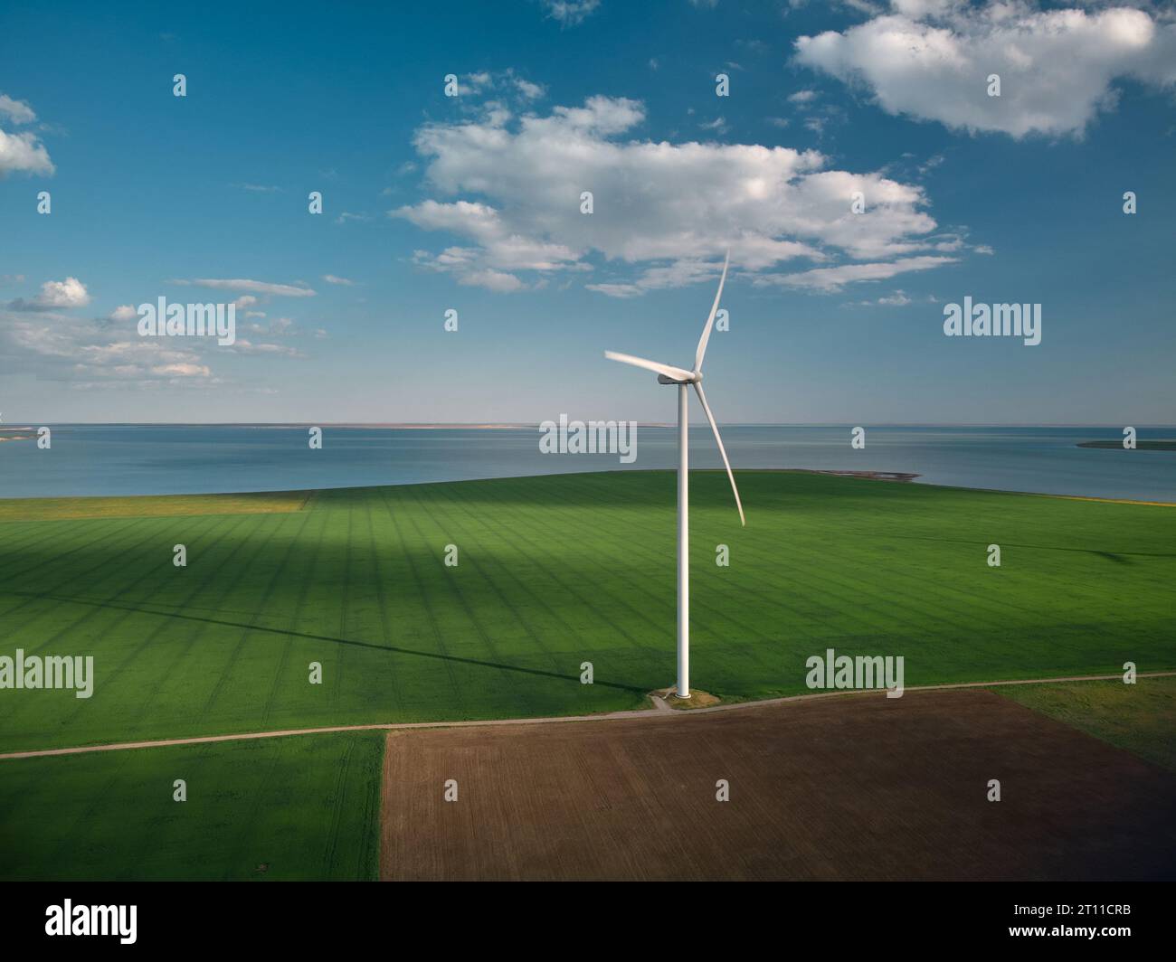 Aerial top view of wind turbines and agriculture field near the sea at ...