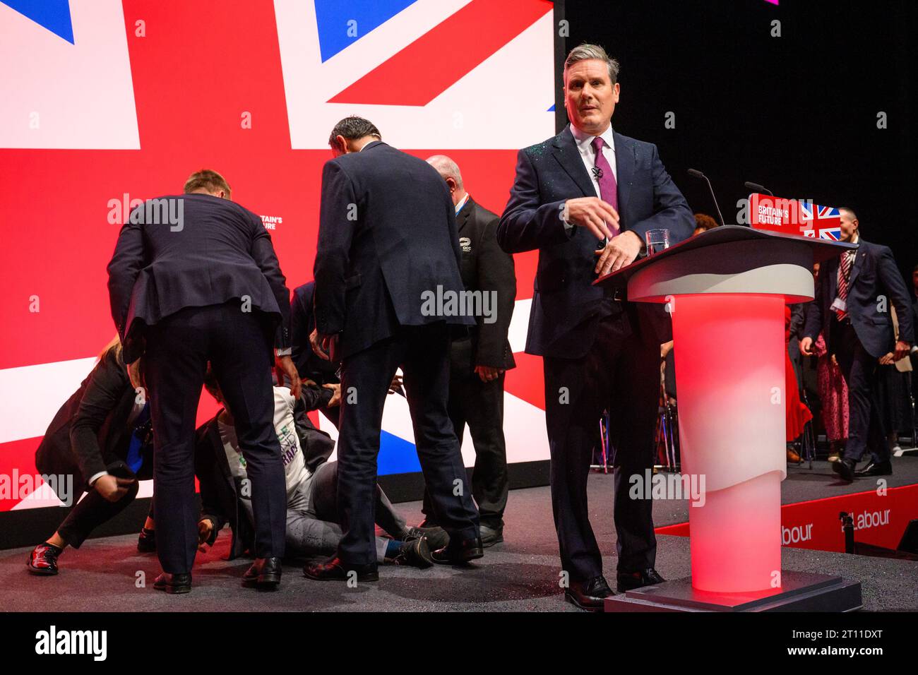 London, UK. 10 October 2023. A protester throws glitter over Labour ...