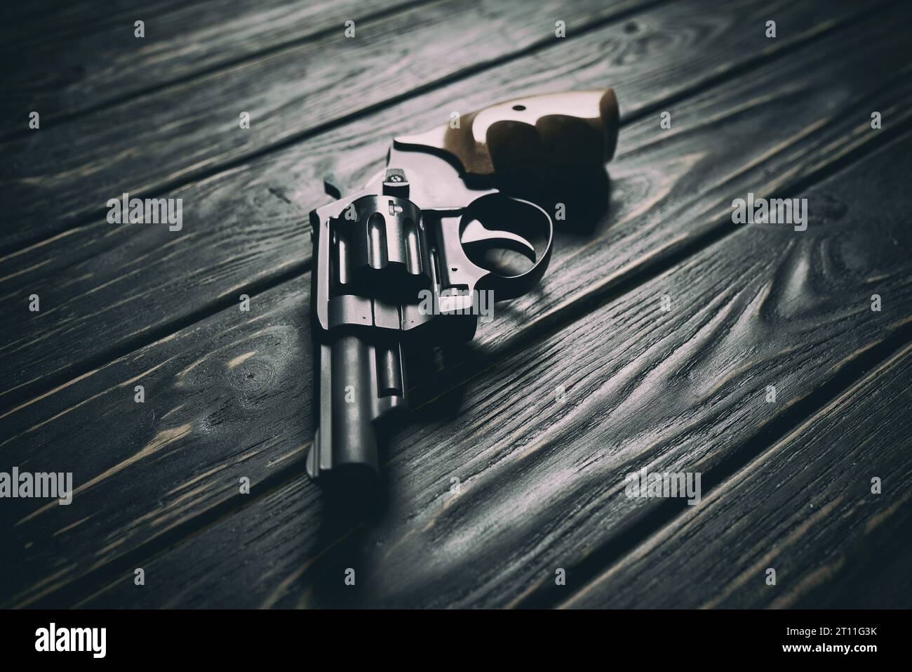Black revolver pistol on dark wooden background Stock Photo - Alamy