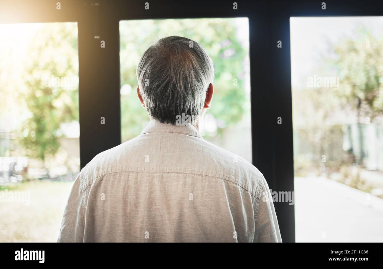 Back, mature man and thinking by window, depression and anxiety alone ...