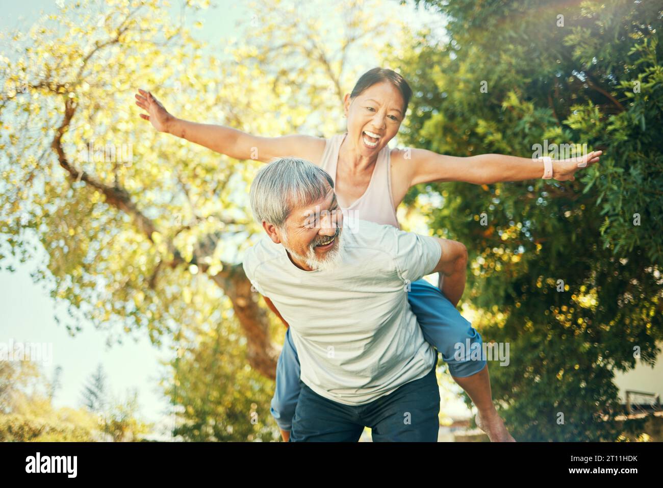 Couple, smile and piggyback in nature for fun, excited and playful in freedom, energy and joy ...