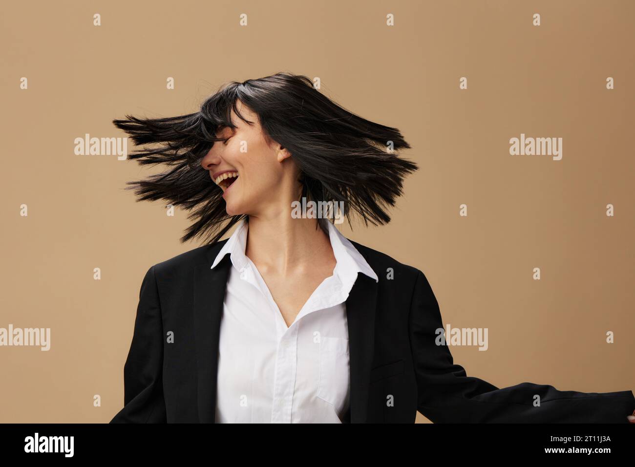 Happy dancing adorable brunet lady in classic suit throws head with ...