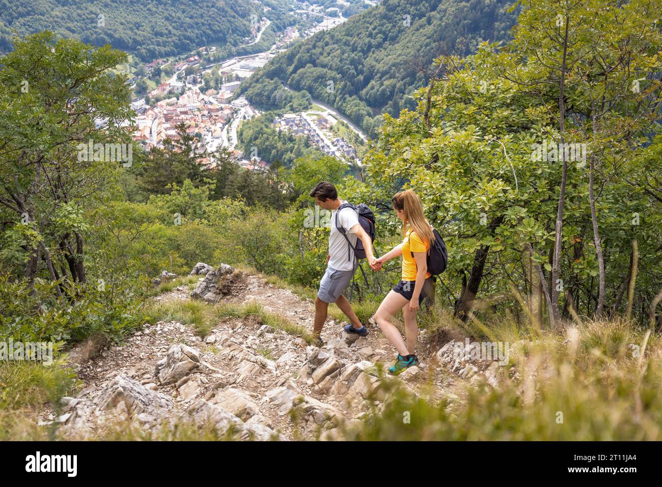Man and woman exploring mountain nature hiking along a forest trail ...
