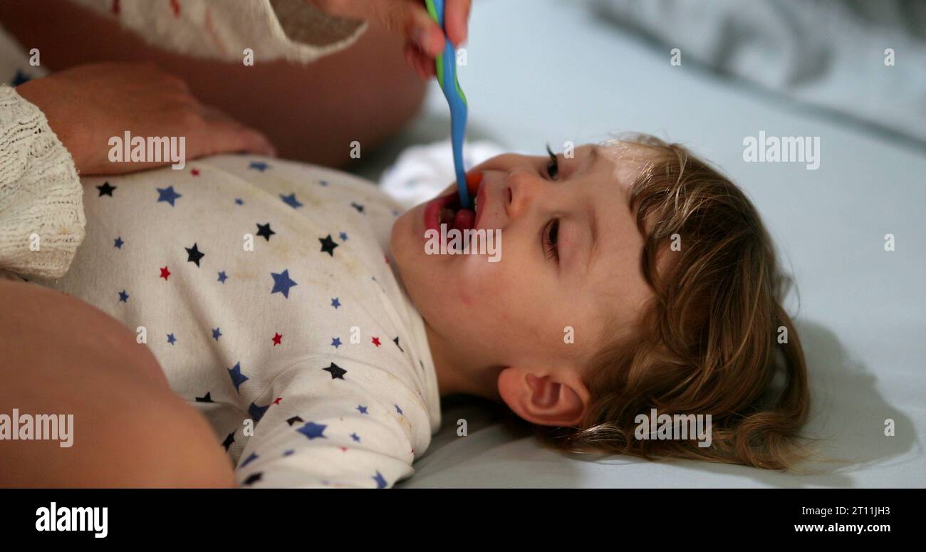 Mother brushing toddler son teeth before bed. Parent brushes little boy ...