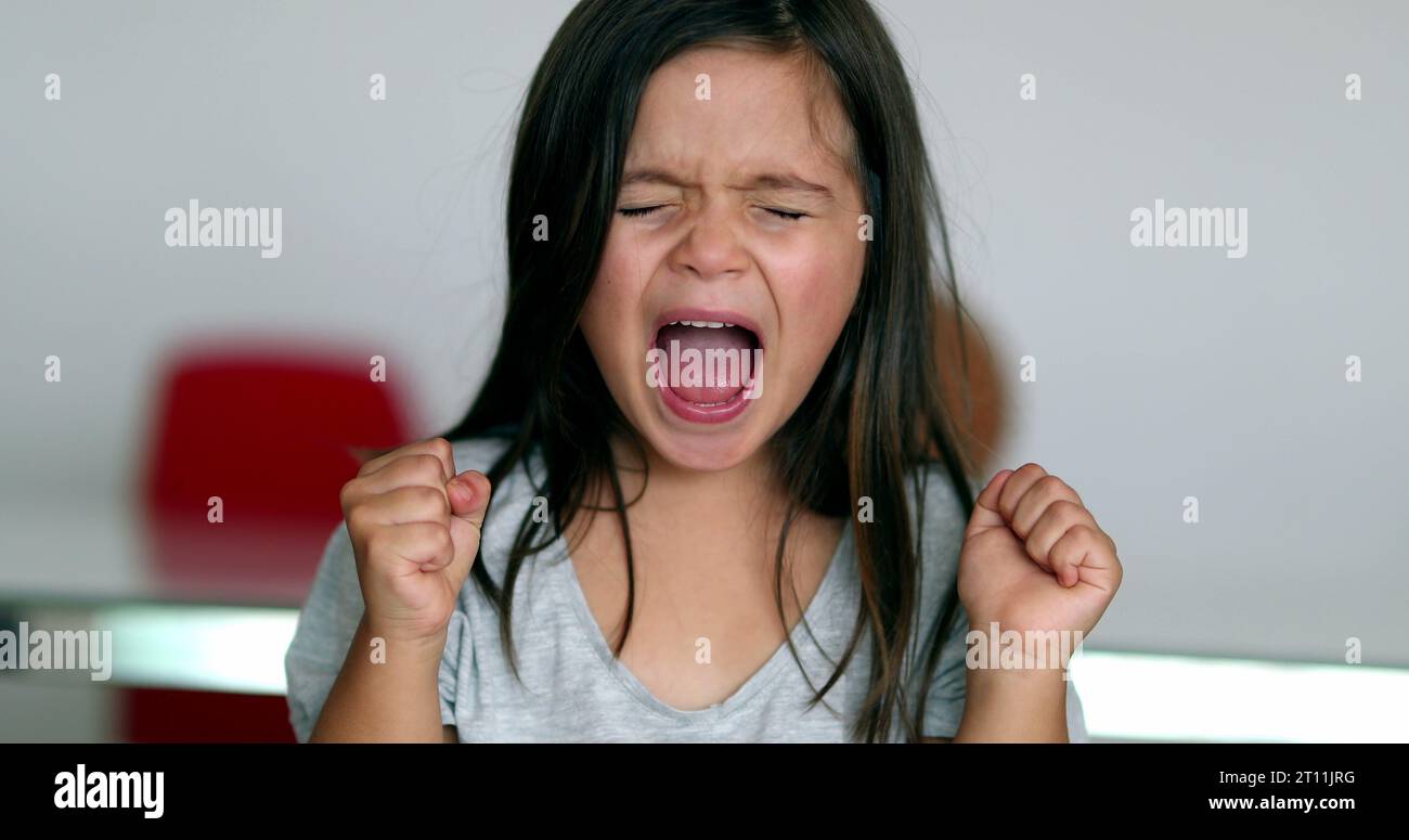 Upset little girl yelling feeling angry Stock Photo - Alamy