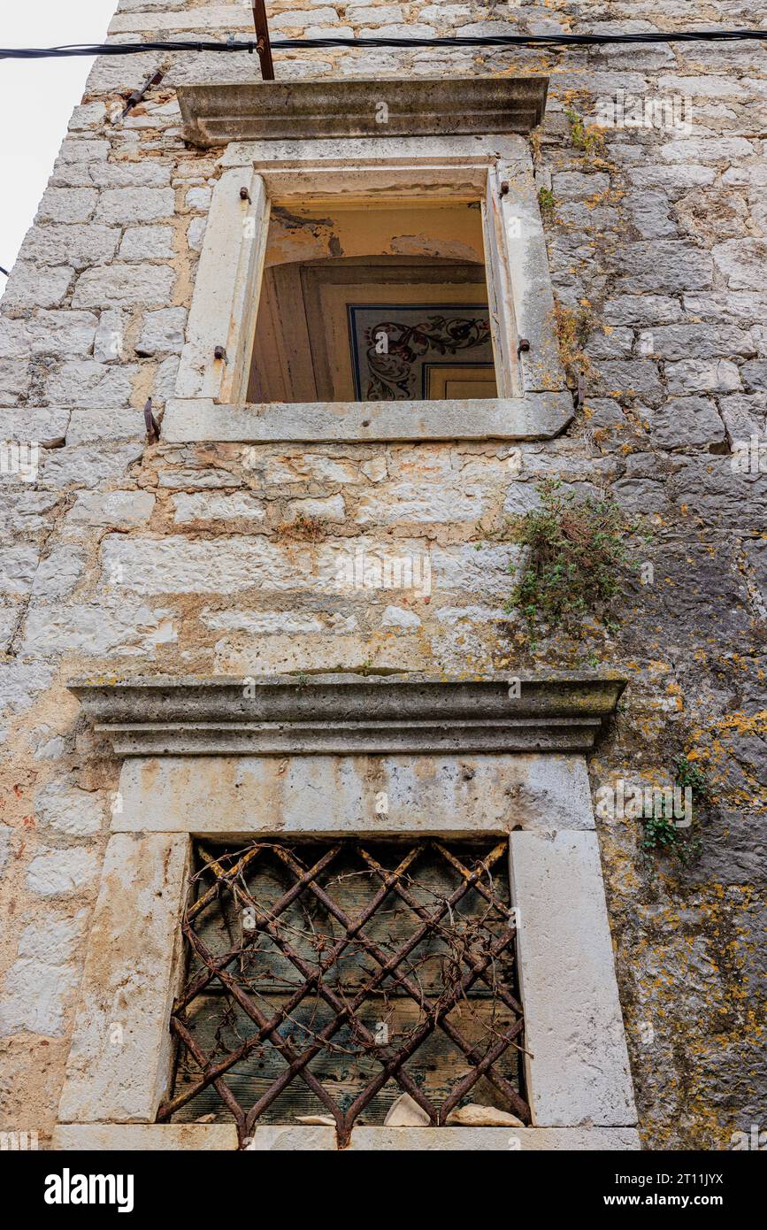 abandoned stone walled house with decorative ceiling seen through ...