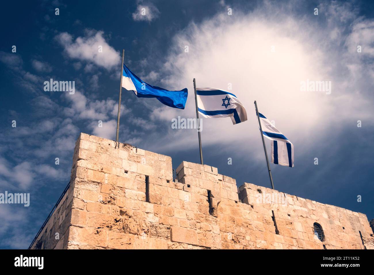 Three flags waving in the wind on Jerusalem city walls against the blue ...