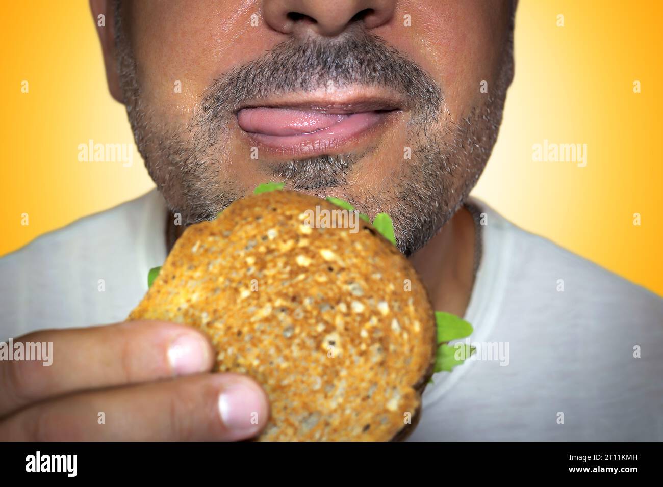 Irresistible craving for junk food. Close-up of a hungry man biting ...