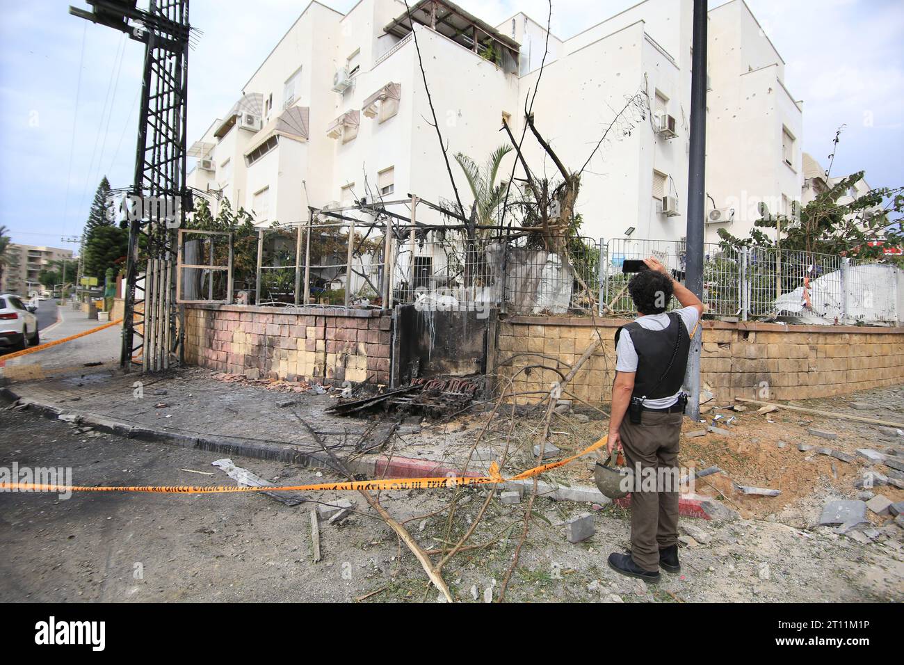 A man seen taking a photo of a damaged house in the southern Israeli ...