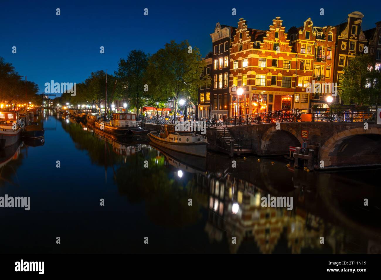 Netherlands. Summer night on the Amsterdam canal. Dancing Dutch houses ...