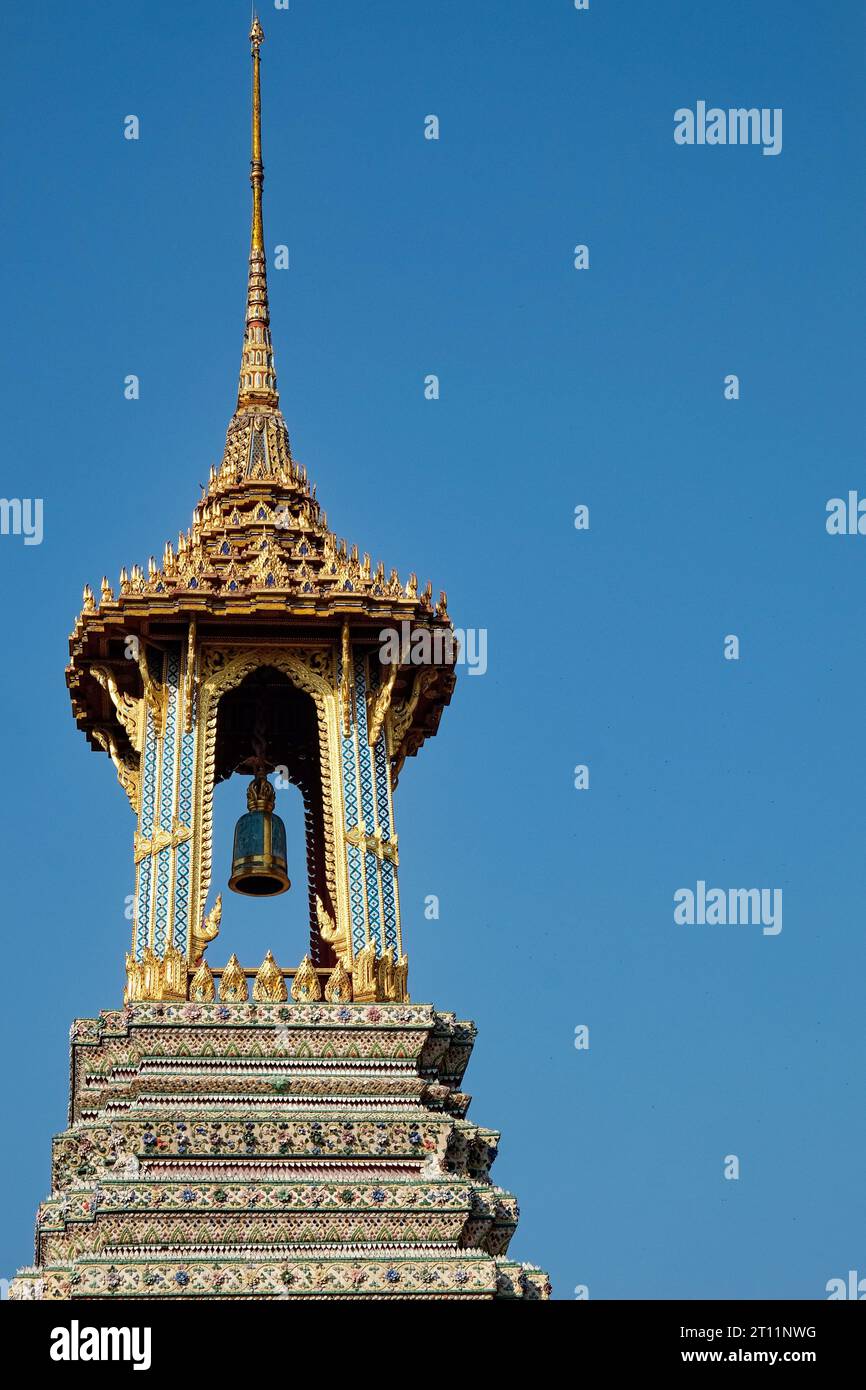 An exquisite Thai temple bell tower, featuring a luminous golden roof ...