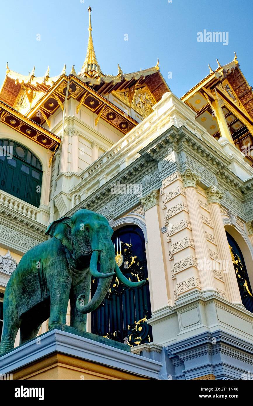Before an ornately decorated structure, a monumental elephant sculpture ...