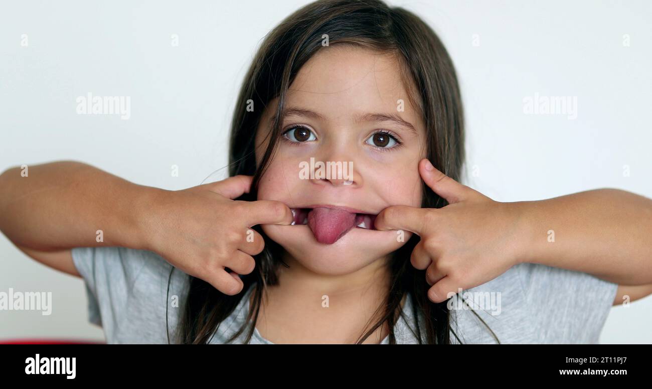 Little girl grimacing, sticking ongue out. Child grimace making funny ...