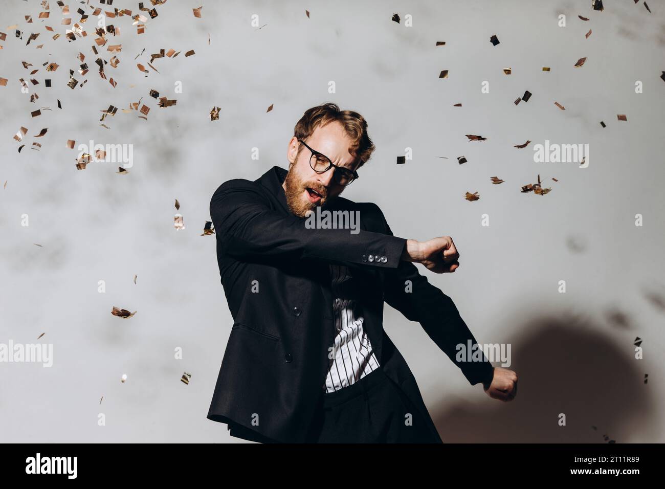 Celebration time. Portrait of a happy guy dancing under glittering ...