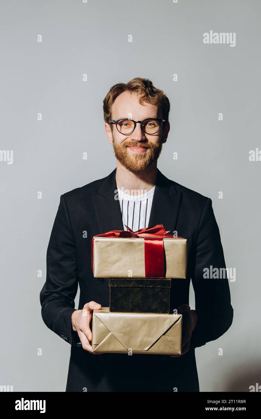 Celebration Time. Portrait of a happy guy holding stack of present ...