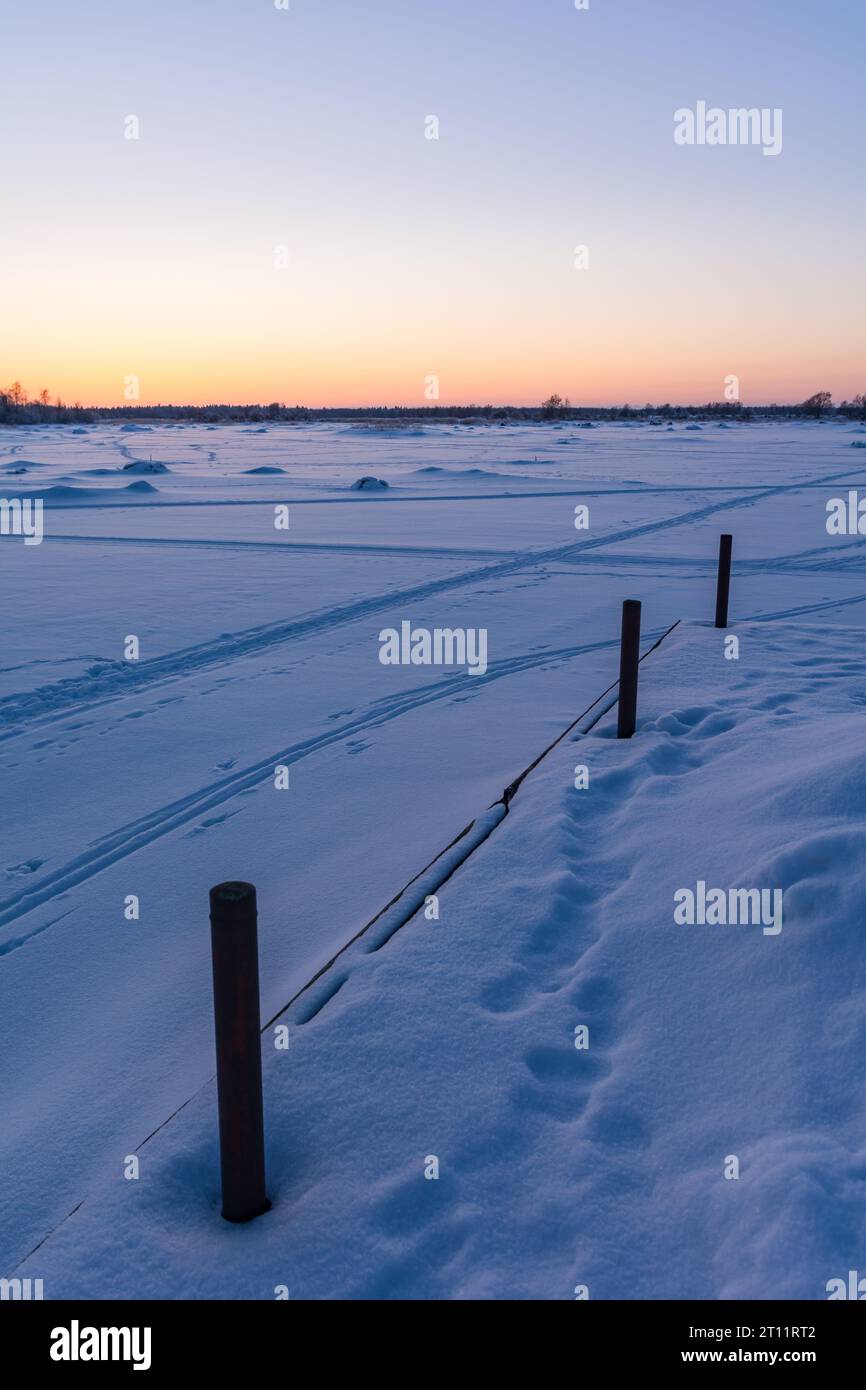 Snowy bay of the sea with ski tracks and snow covered jetty in Finland ...