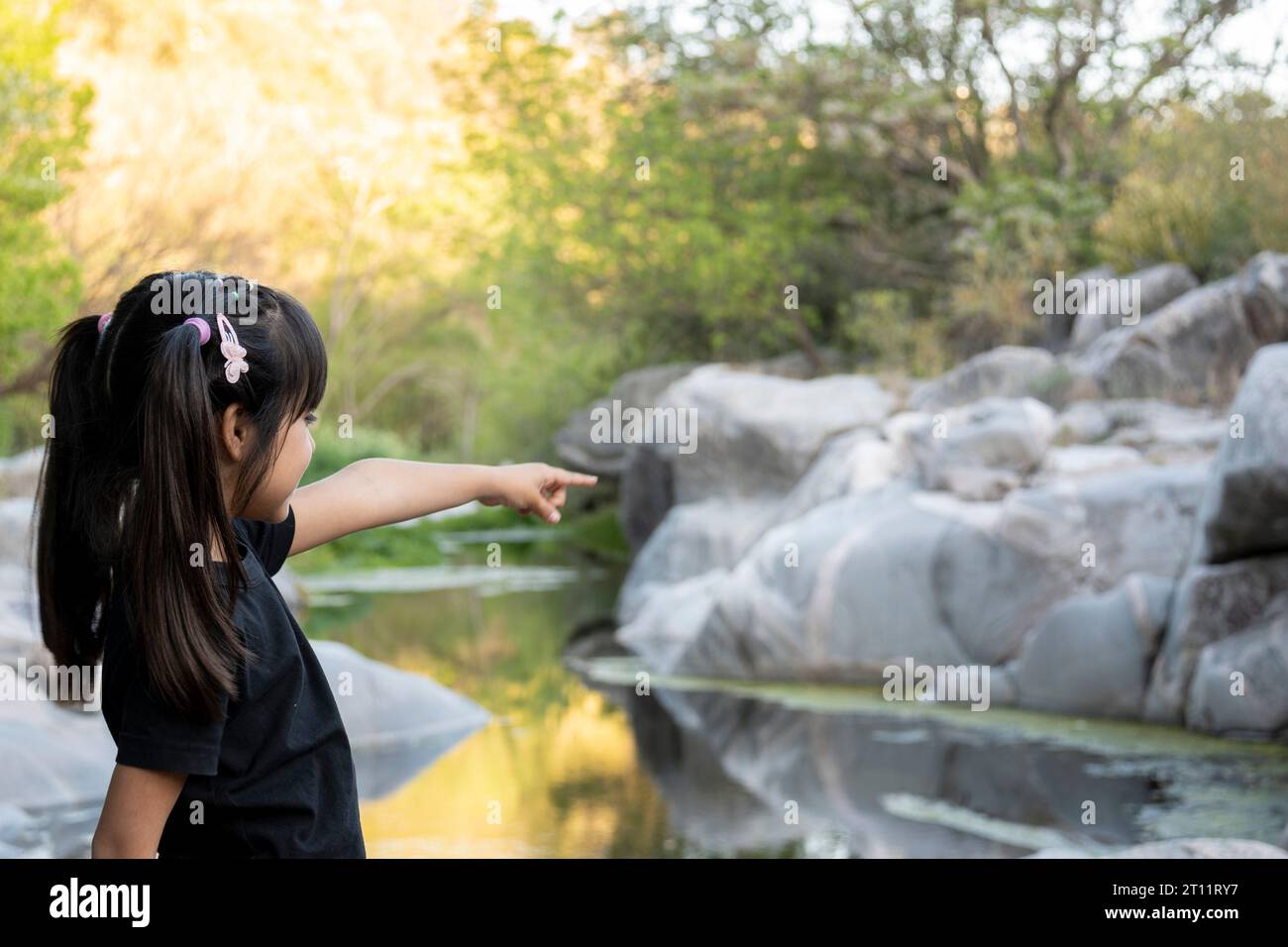 Sweet little girl pointing towards interesting things in a lake Stock ...