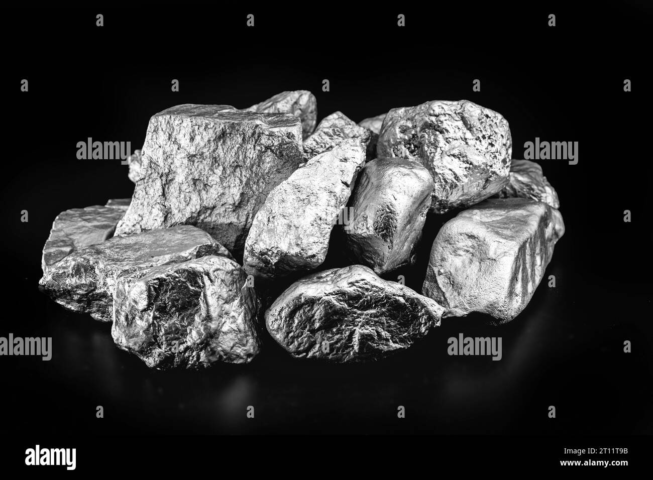 piece of silver or platinum on the stone floor, on black background ...