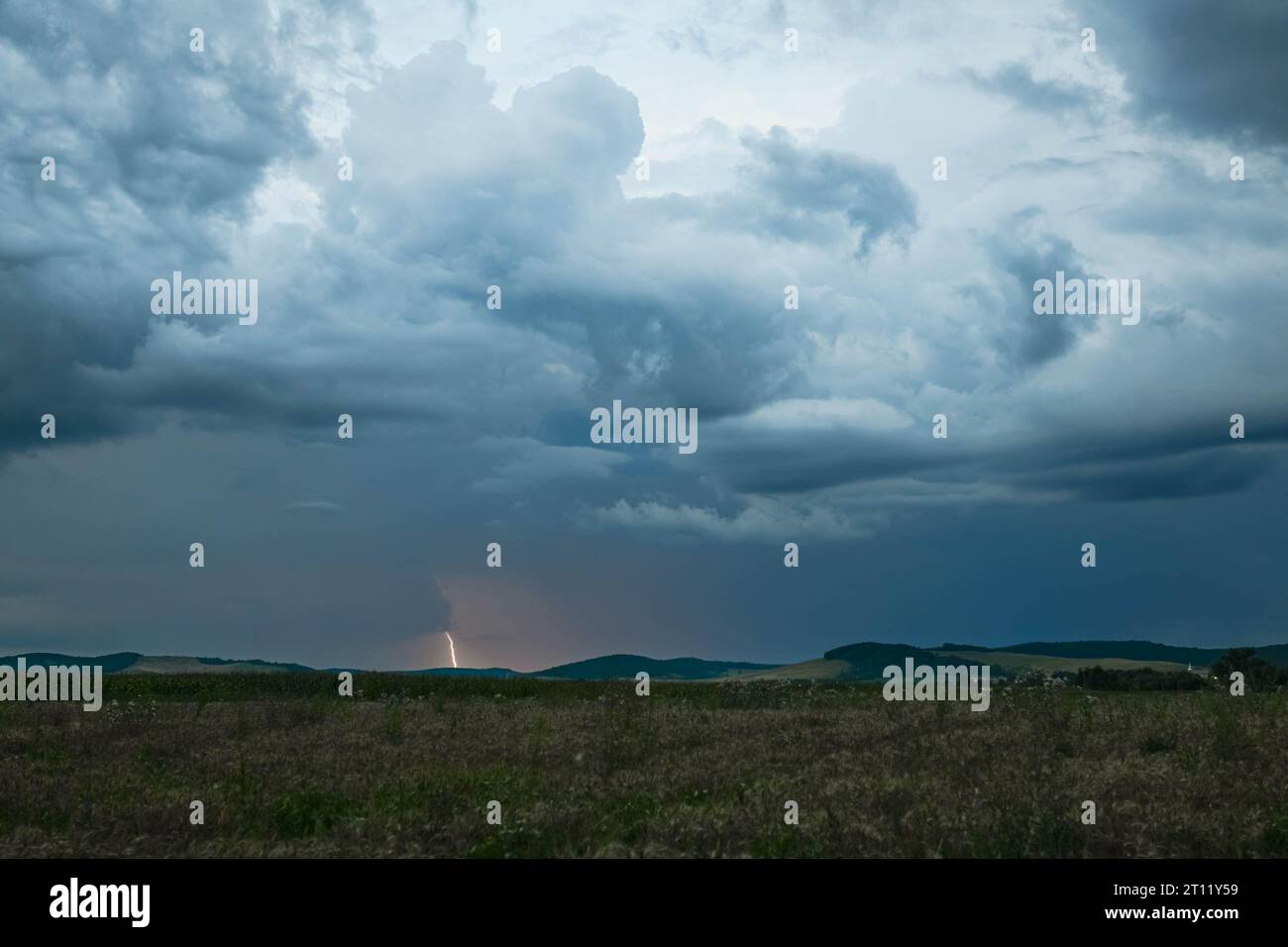 A lightning bolt shoots from a distant thunderstorm cloud in the ...