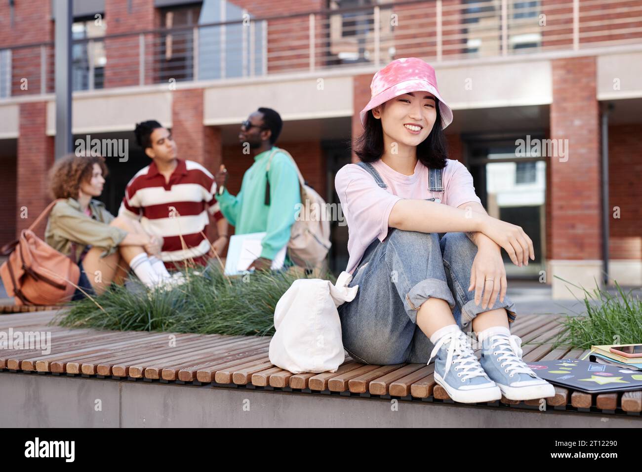 Full length portrait of fun young Asian woman wearing denim overalls on ...