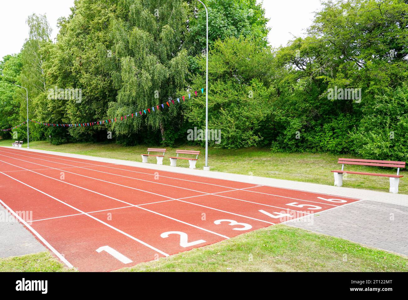 A school stadium running track with a red surface and six numbered ...