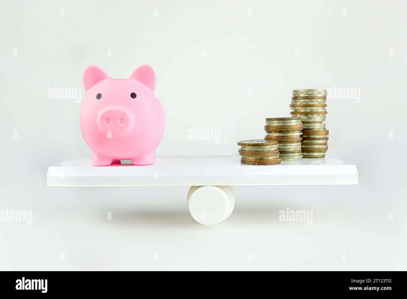 Close-up Of Balancing Stacked Of Coins Money and pink pig spear On on ...