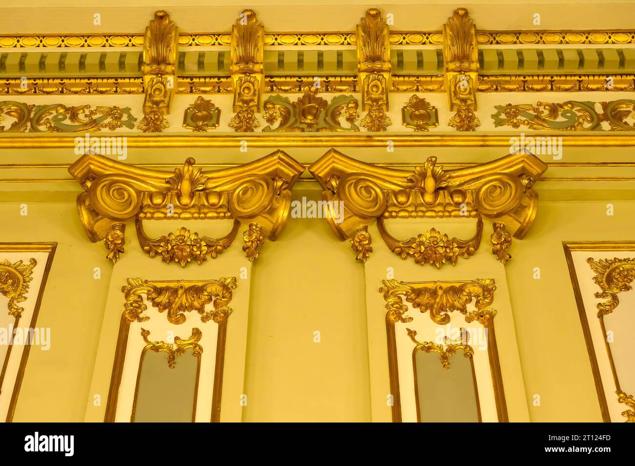 Low-angle view of column capitals. Gold-colored luxurious decorations ...