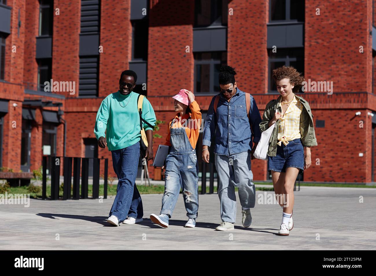 Full length view at multiethnic group of young students walking ...