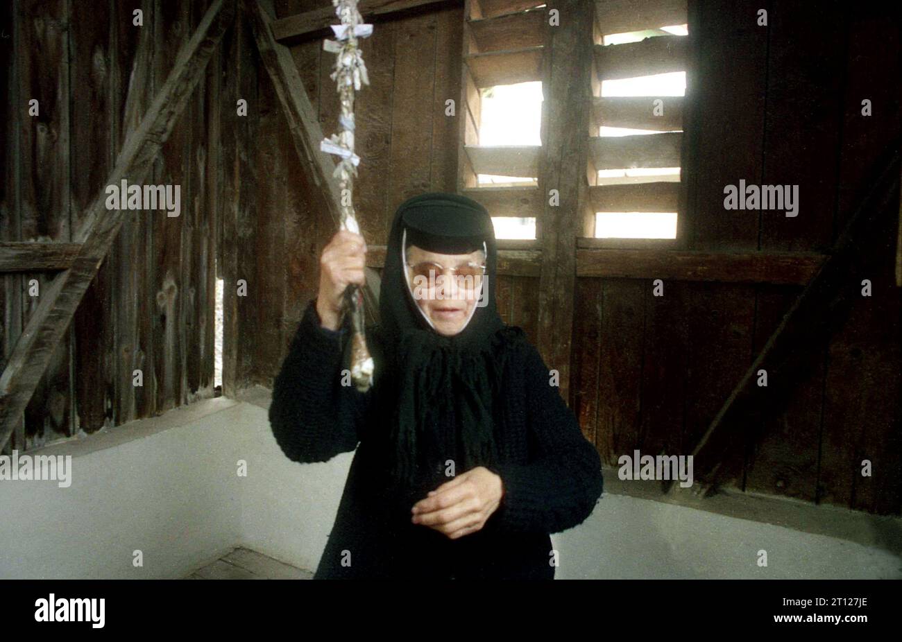 Arges County, Romania, 2000. Nun pulling the rope to ring the bell at ...