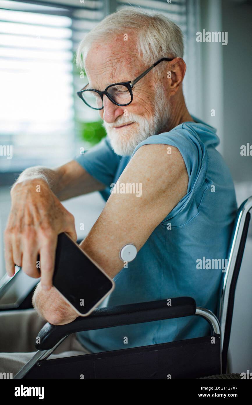 Diabetic senior man checking blood glucose level at home using ...