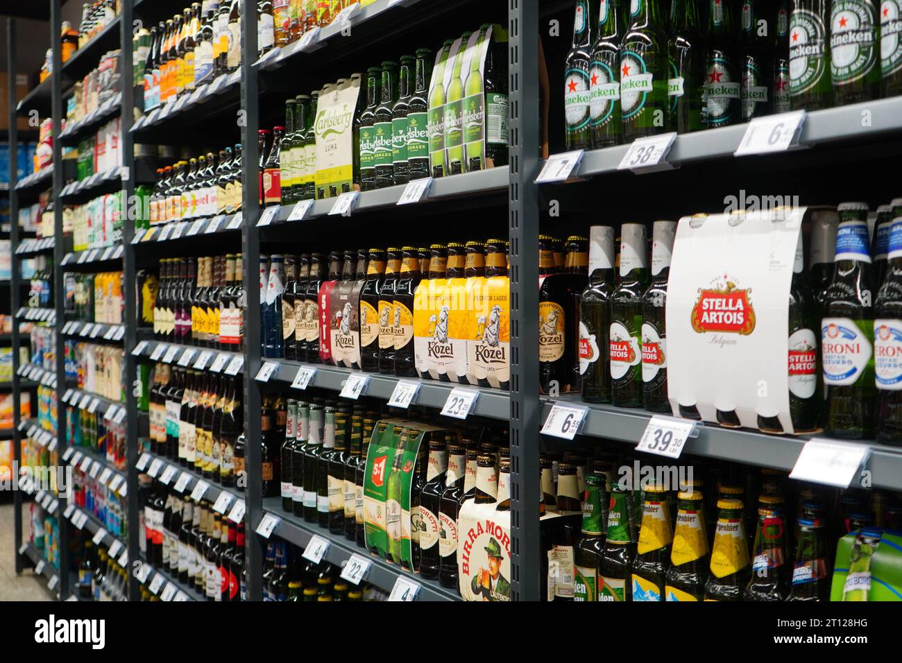 Bottles of beer of various brands displayed neatly on supermarket ...