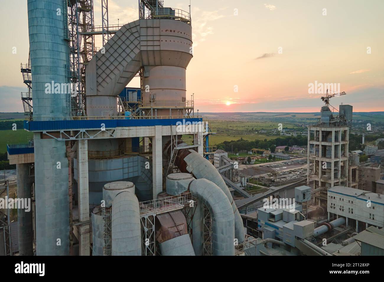 Cement plant with high factory structure and tower cranes at industrial ...
