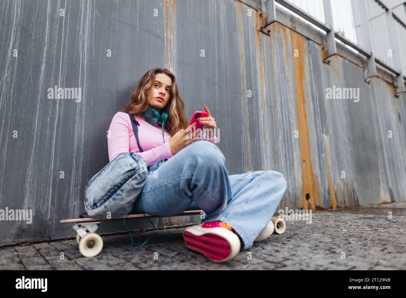 Portrait of generation z girl student sitting outdoors in the city ...