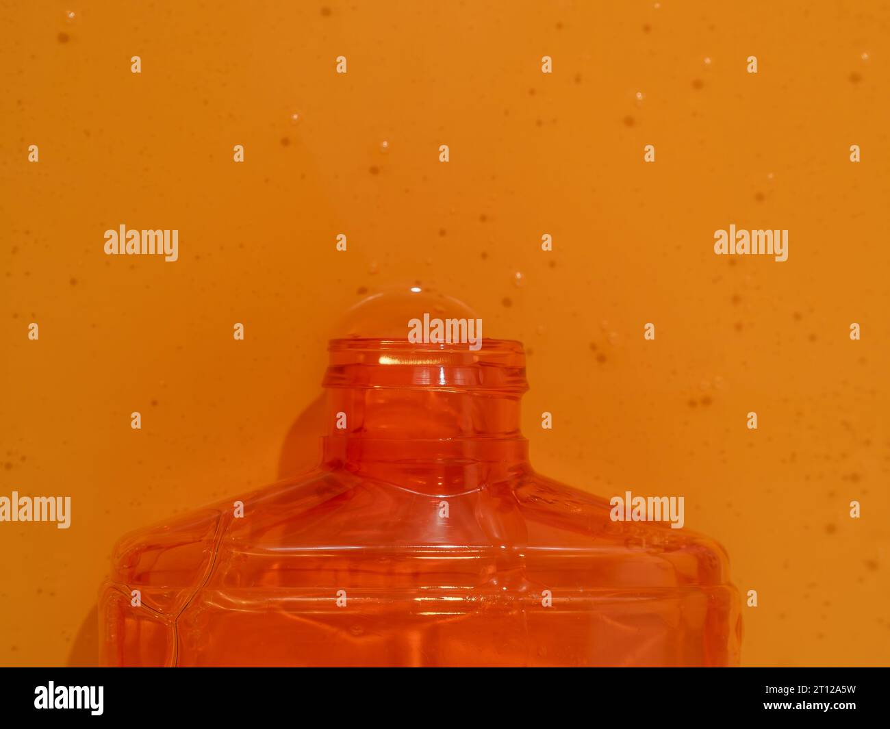 Liquid shower gel gracefully pours from a container onto a bright ...