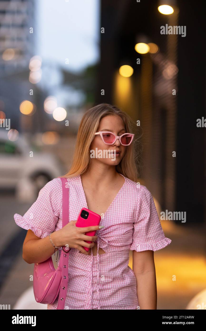 Gen Z girl in pink outfit before going the cinema to watch movie. The ...