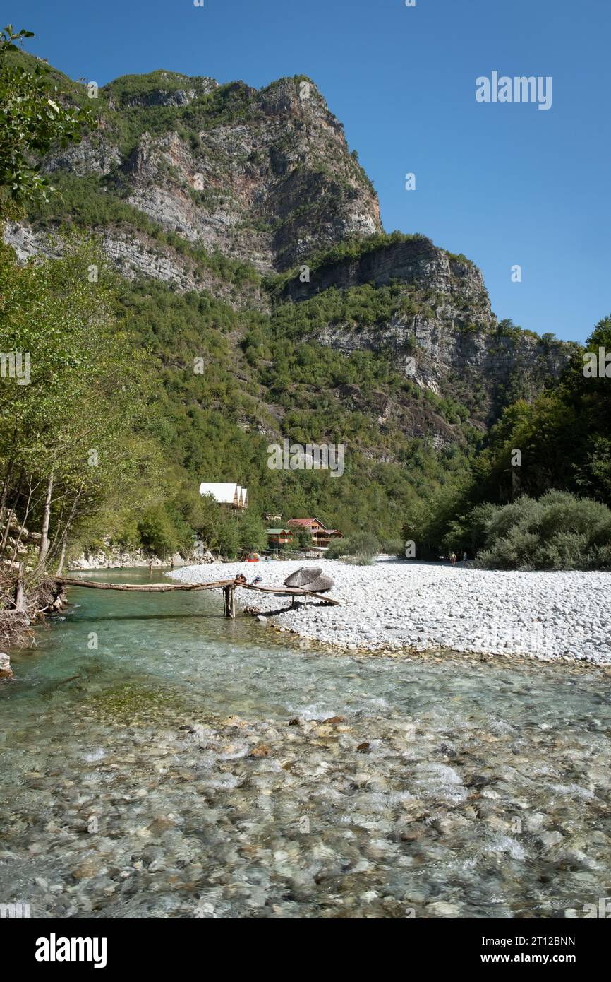 A wooden bridge over a shallow stream at River Shala resort village on ...
