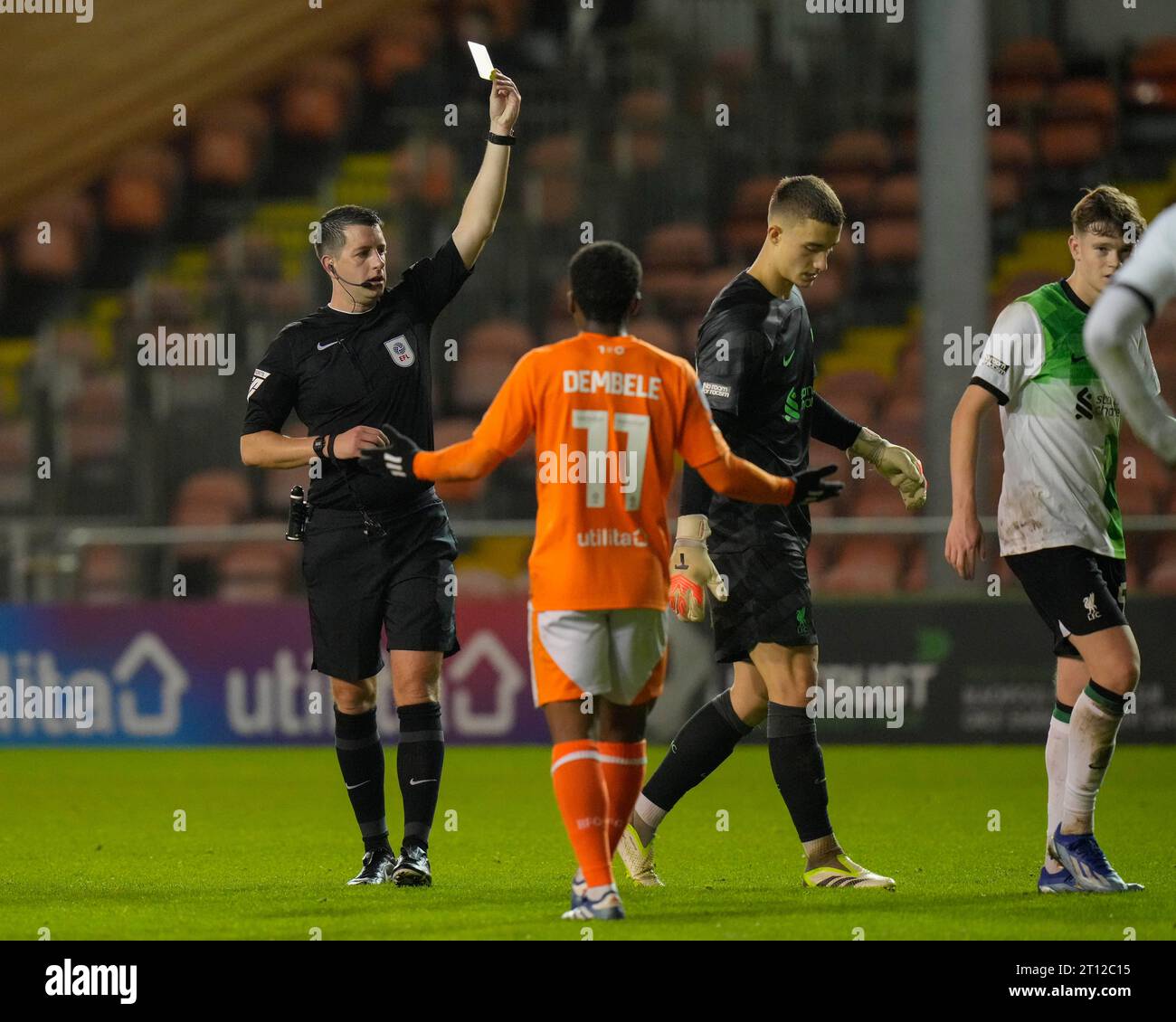 Referee Scott Simpson shows a yellow card to Mateusz Musialowski #92 of ...