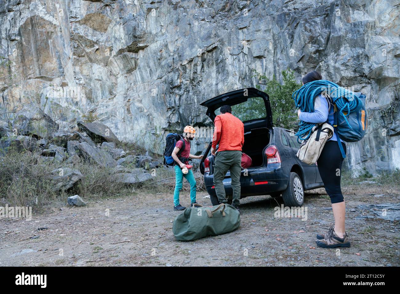 Group of young people at the foot of the mountain unloading rock ...