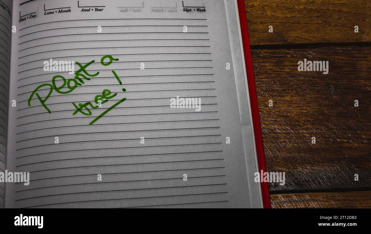 Plant a tree, handwriting text on page of office agenda. Copy space ...