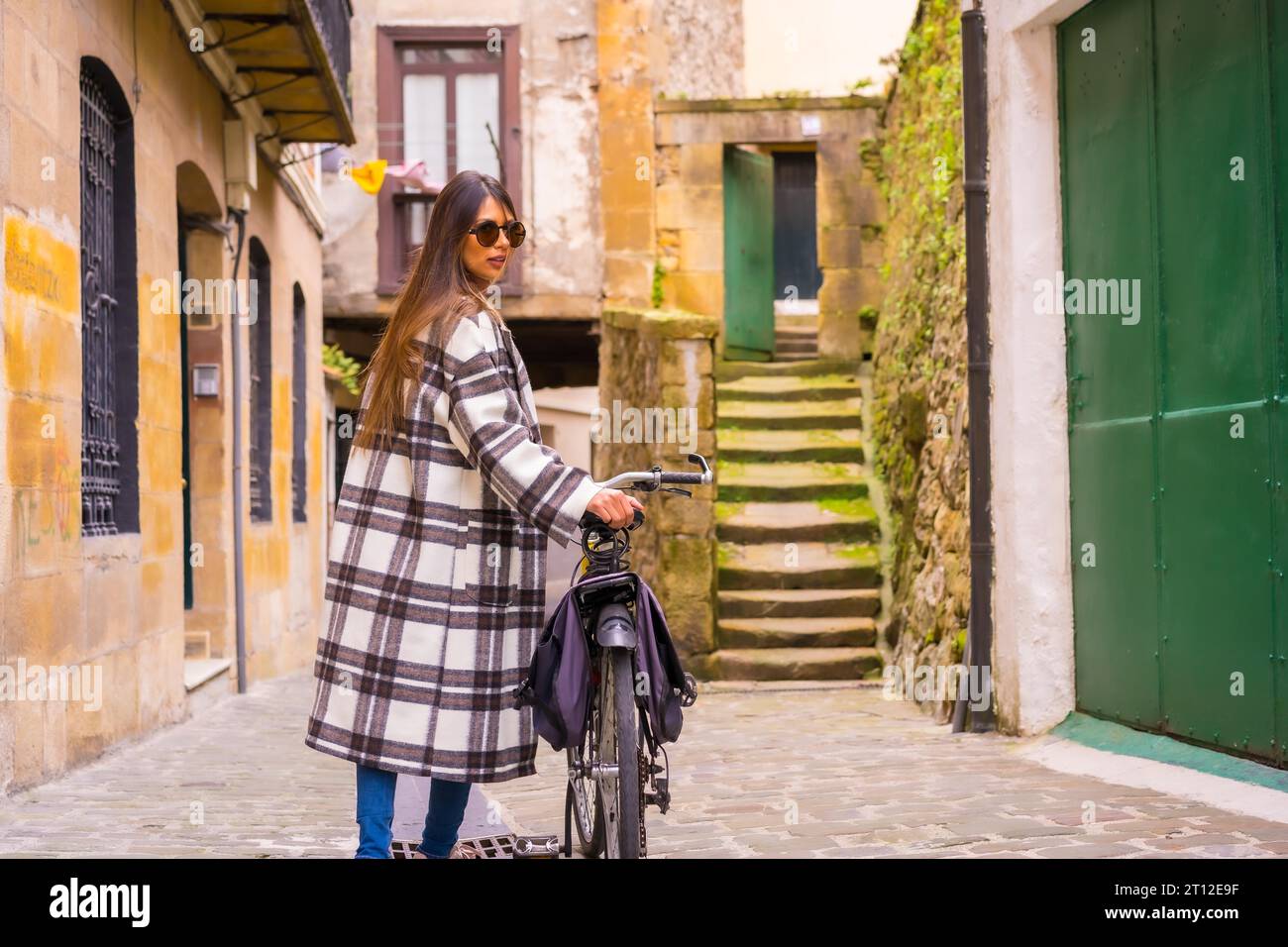 Latin woman doing bicycle tourism in the city. Eco-tourism lifestyle in ...