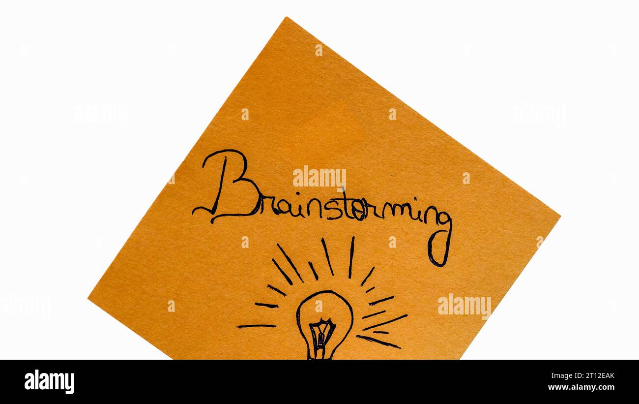Brainstorming handwriting text close up isolated on orange paper with ...