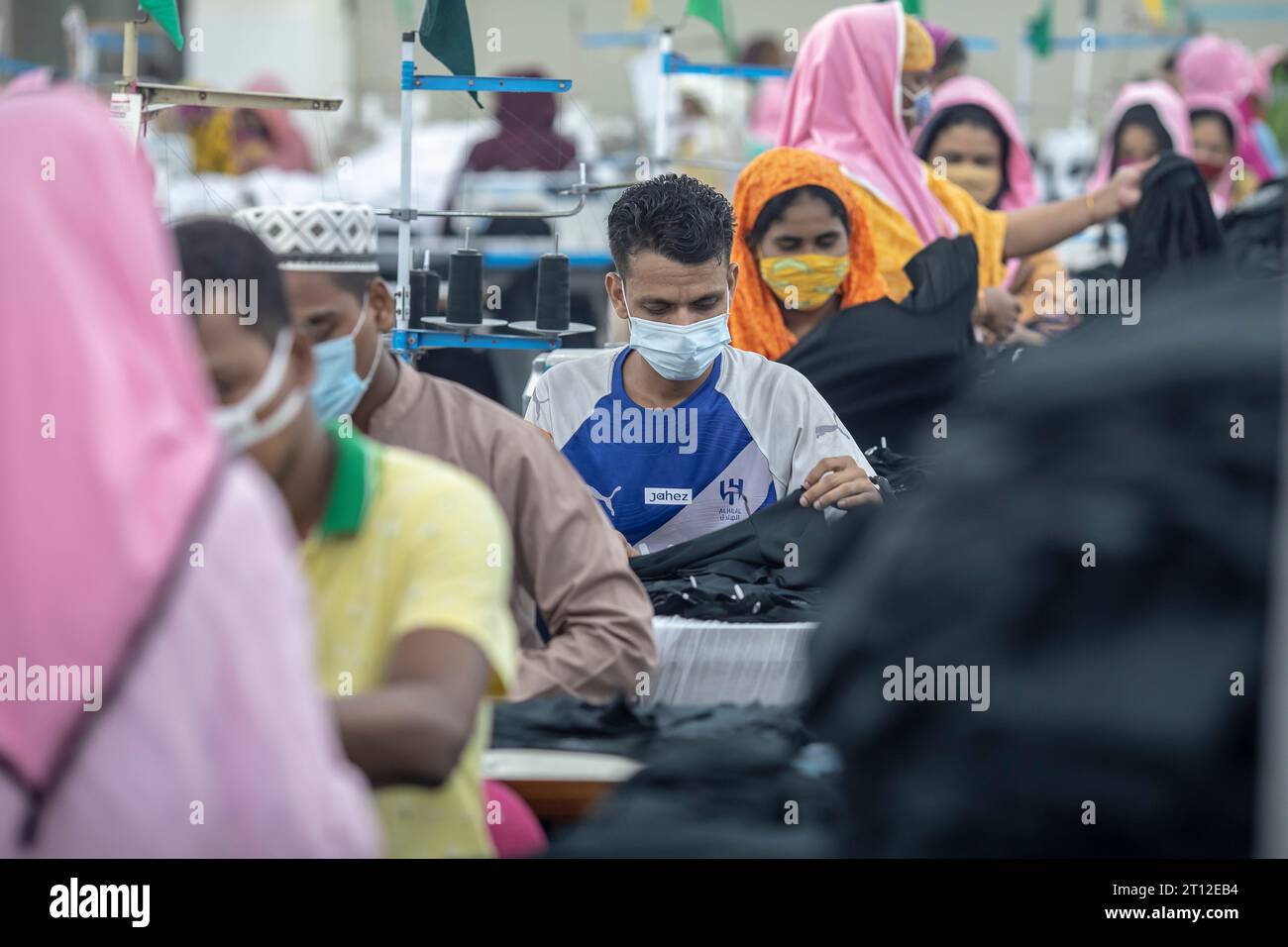 Garment workers work in a sewing section at the Surma Garments Limited ...