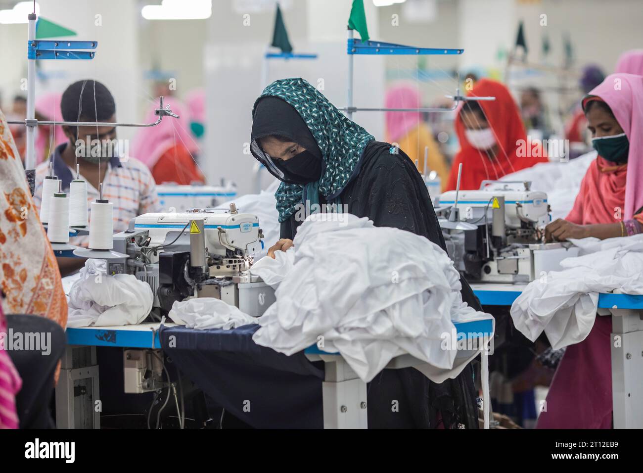 Garment workers work in a sewing section at the Surma Garments Limited ...