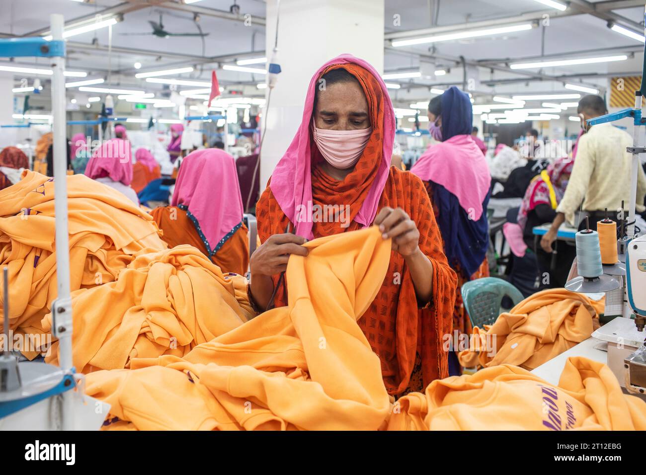 Garment workers work in a sewing section at the Surma Garments Limited ...