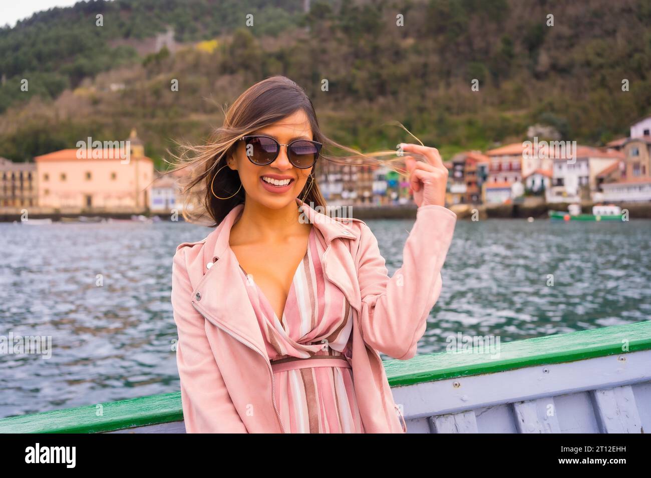 Pretty Latin woman with sunglasses sightseeing on a boat along the ...