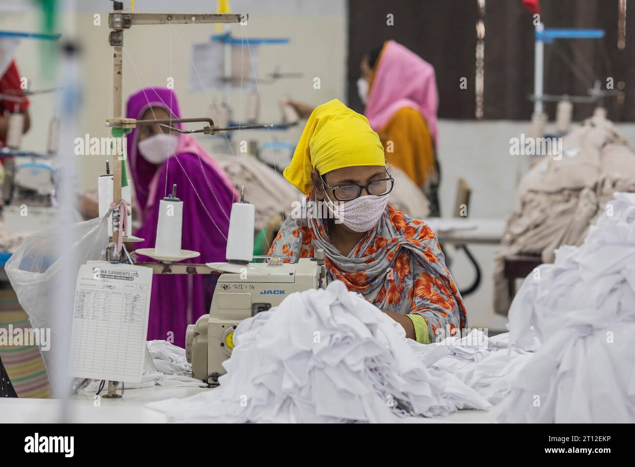 Garment workers work in a sewing section at the Surma Garments Limited ...